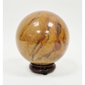 Large polished agate jasper ball, approximately 16cm diameter on wooden ...