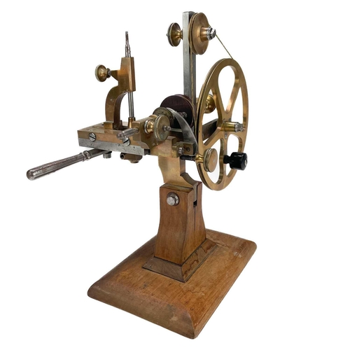 A watchmakers' brass and steel topping tool. Mounted on a walnut base ...