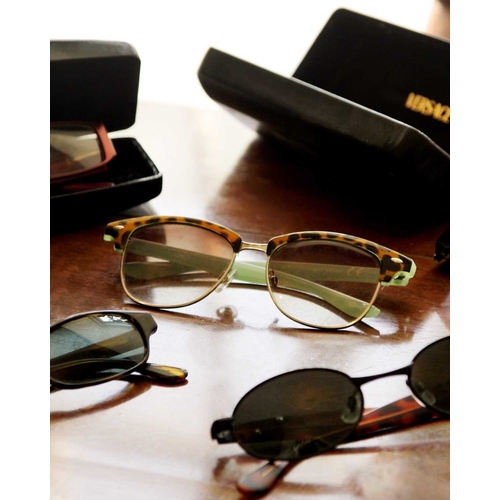 An assortment of sunglasses and purses. Including 'VERACE' sunglasses ...