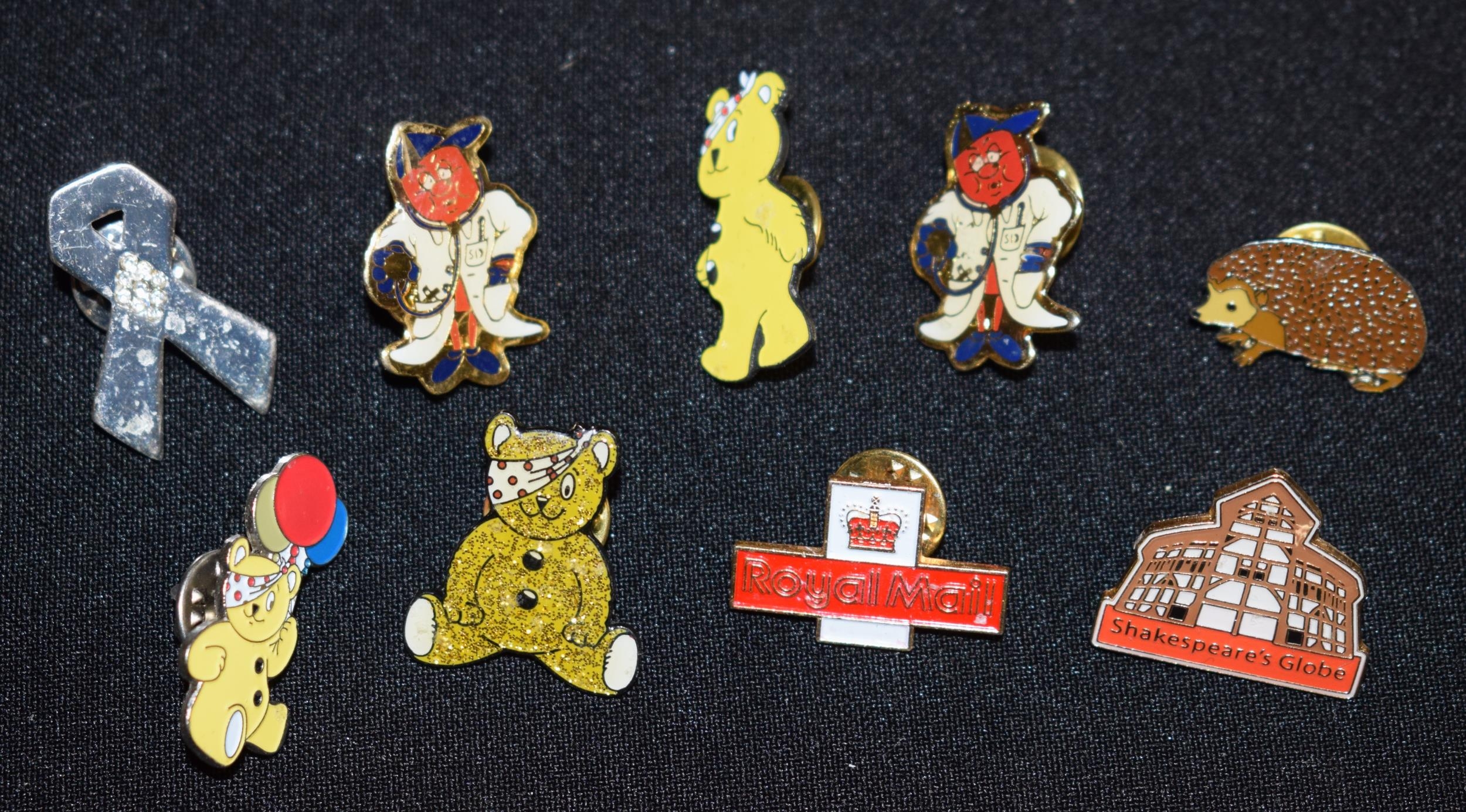 A collection of pin badges to include Pudsey Bear, Royal Mail, a ...