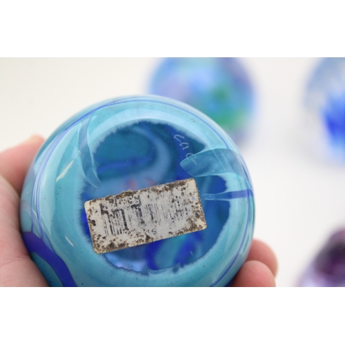 A collection of glass paperweights to include Caithness purple pyramid ...