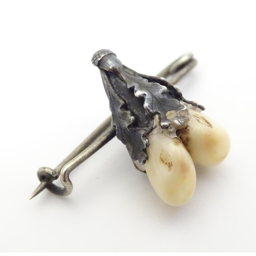 A hunting trophy brooch set with a deers tooth within a white metal ...