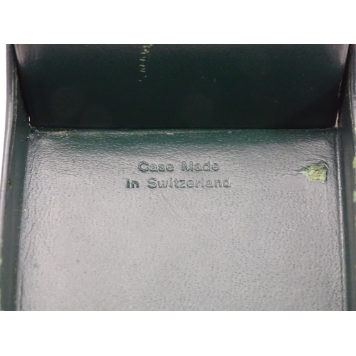 A Looping swiss made travelling alarm clock in green leather covered ...
