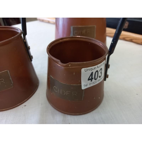 A set of 3 graduated copper cider measures