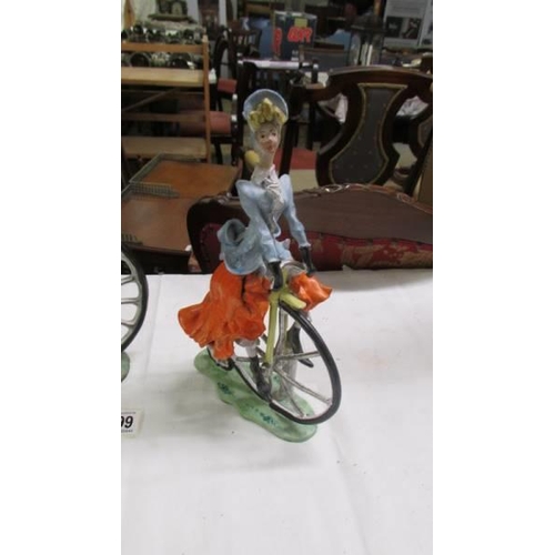 An Italian ceramic male and female figures on bicycle and penny ...
