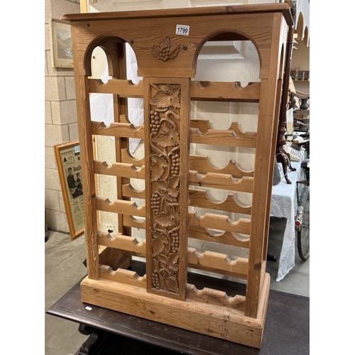 A solid pine wine bottle rack with grape & leaf carved decoration