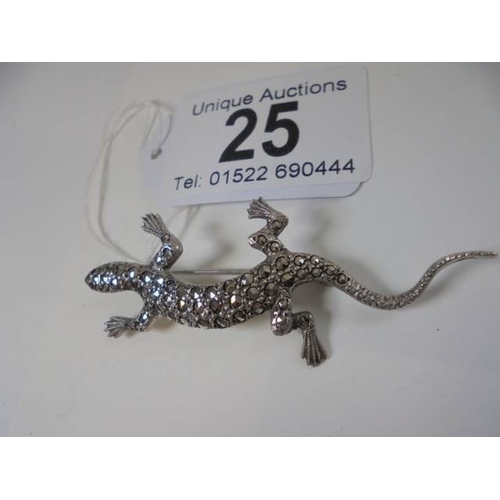 A silver marcasite lizard brooch with ruby red eyes.