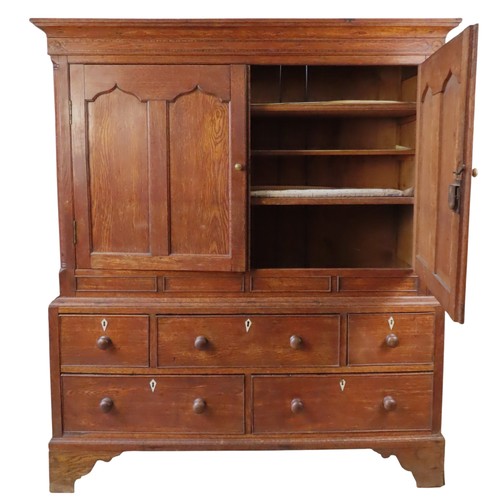 A 19TH CENTURY OAK CUPBOARD ON CHESTin two sections, the top section ...