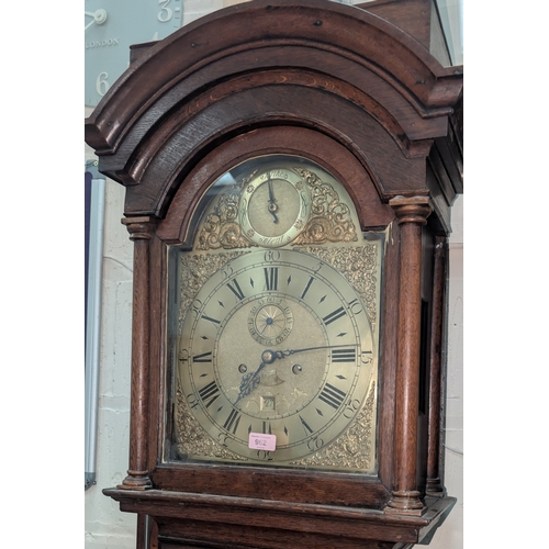 An 18th century longcase clock with arched top and turned pillars to ...