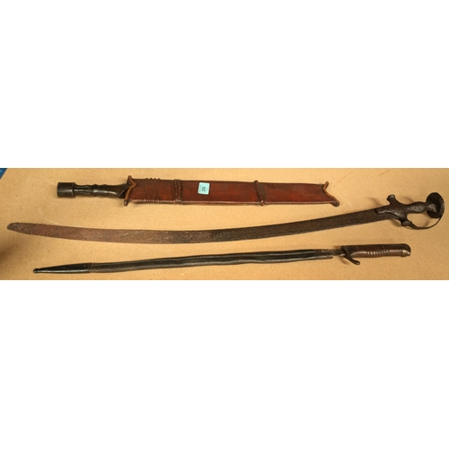 An African style tribal sword in scabbard, a rusted Middle Eastern ...