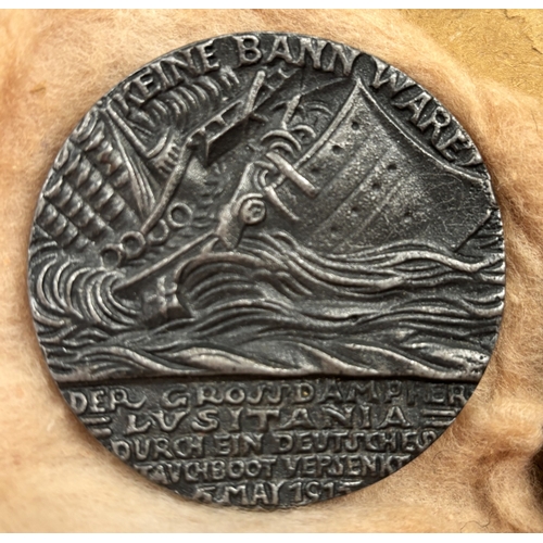 A medal commemorating the sinking of the Lusitania and a HMS Victory coin