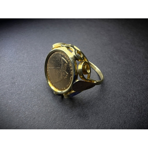 A yellow metal ring set with a coin commemorating Queen Nefertiti ...