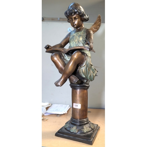An Art Neveau style bronze figure of winged child sat reading on top of ...