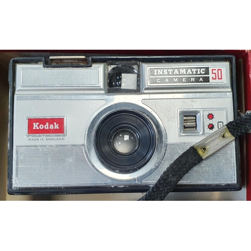 Vintage Kodak Instamatic 50 camera and a Winmau dartboard with darts,