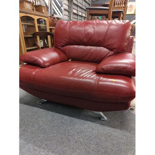 Large Red leather cuddle chair with chrome feet.