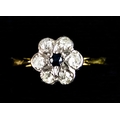 A Sapphire and Diamond Flower Head Ring, set with a central sapphire ...