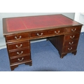 A reproduction mahogany kneehole double pedestal desk with red leather ...