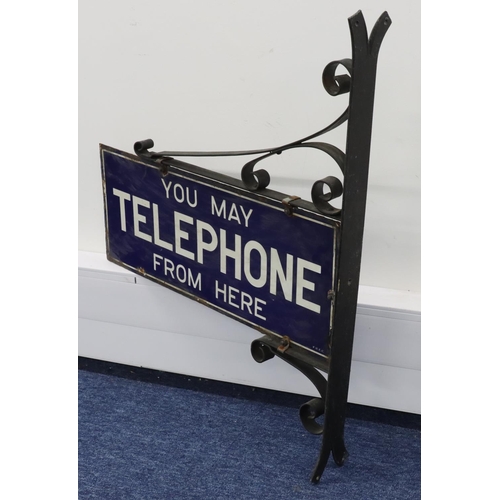 A vintage double-sided enamel sign "You May Telephone From Here ...