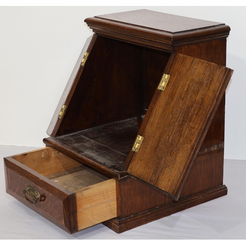 An oak table top cabinet with sloping front and 2 panelled doors, 1 ...