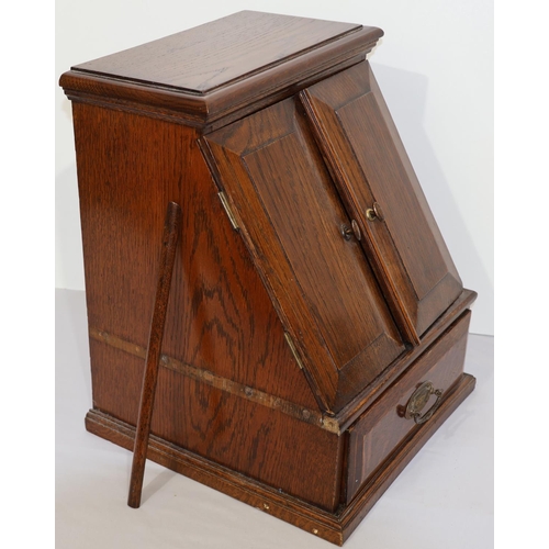 An oak table top cabinet with sloping front and 2 panelled doors, 1 ...