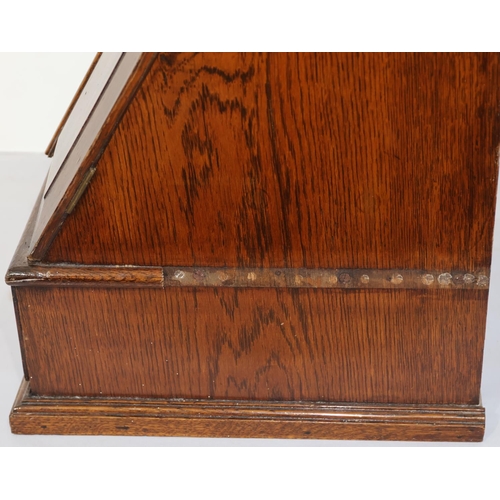 An oak table top cabinet with sloping front and 2 panelled doors, 1 ...