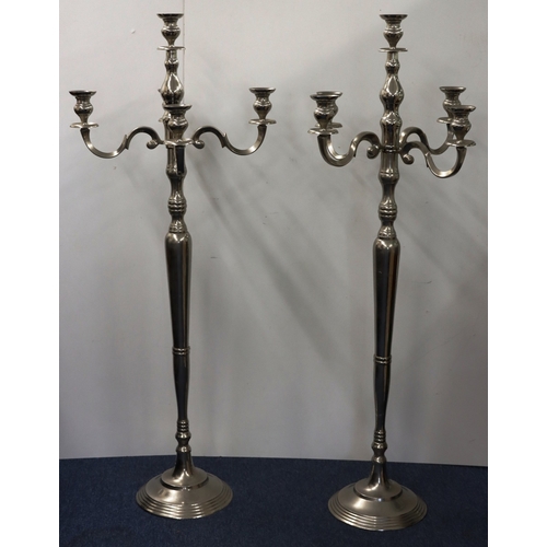 A pair of tall silver coloured candlesticks 143cm high, bases 29cm ...