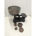 A large vintage cast iron weighing scale with copper bowl and Avery weights