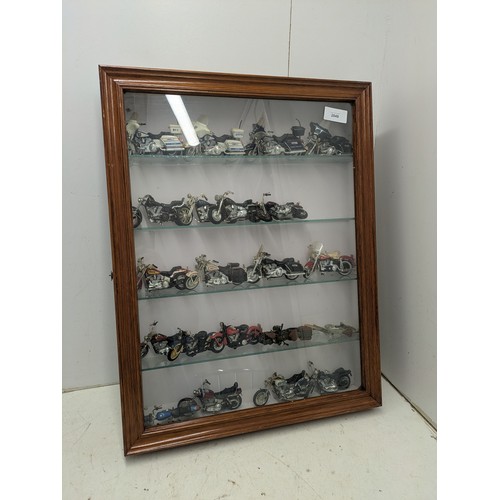 A collection of 21 Maisto motorcycle models in a glass Fronted display case