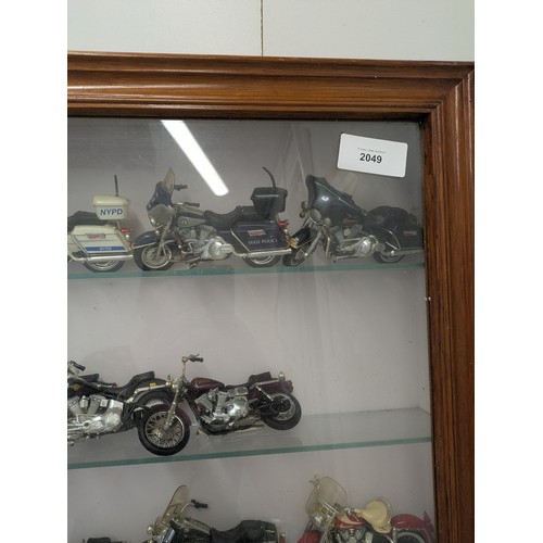 A collection of 21 Maisto motorcycle models in a glass Fronted display case