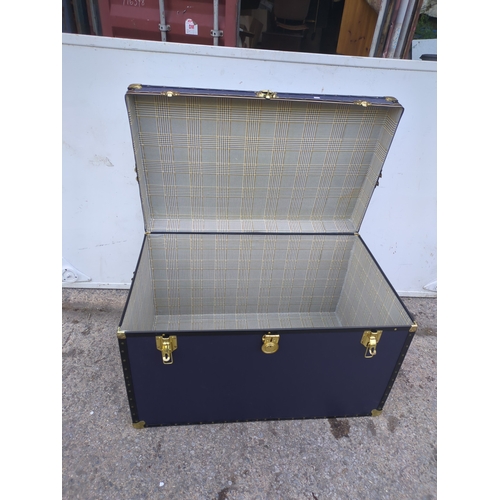 A large canvas storage trunk with brass latches and reinforcements