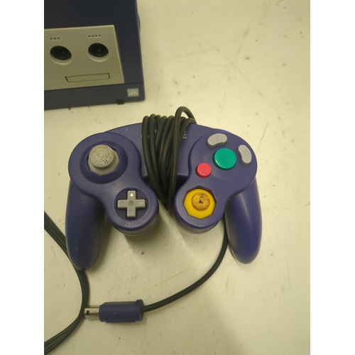 A purple Nintendo Gamecube console with cables and controller