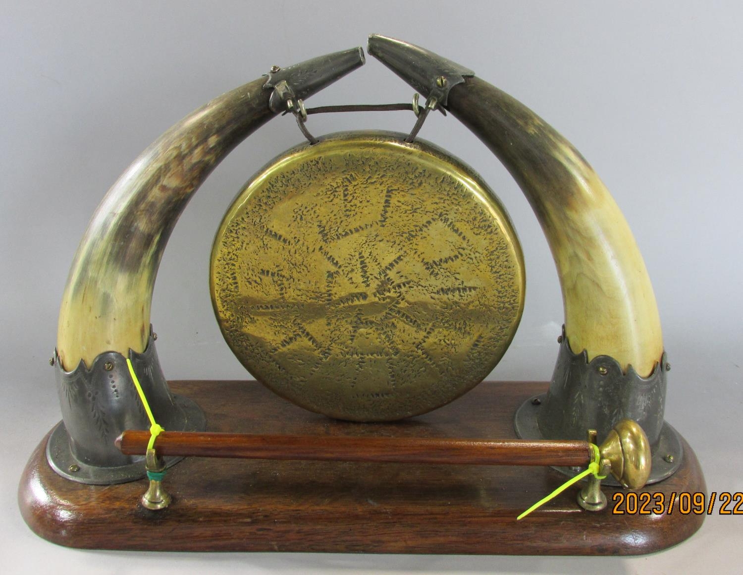 A small Victorian brass dinner gong suspended from cow horn tips raised ...