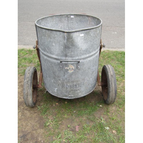 A vintage two wheeled water barrow, the iron frame supporting a ...