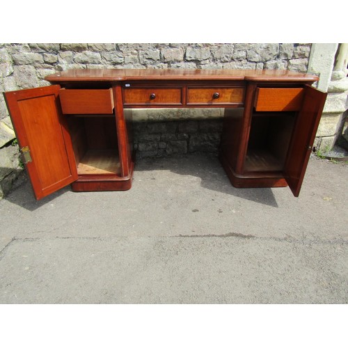 A Victorian mahogany inverted breakfront desk with two central drawers ...