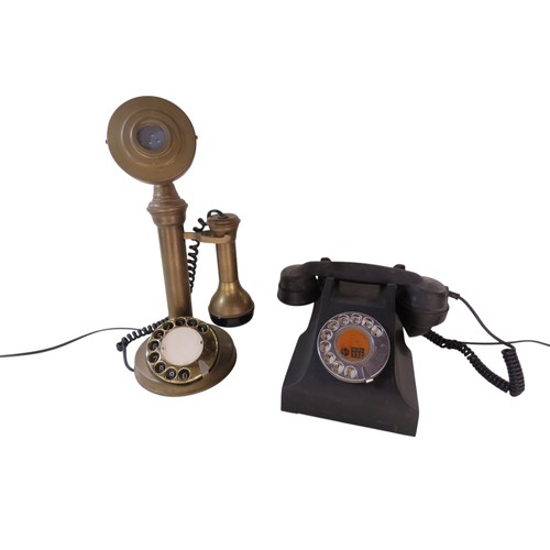 A vintage black Bakelite telephone set together with a reproduction ...
