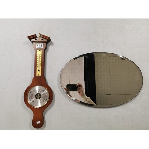 Modern barometer with a thermometer along with a bevel glass mirror ...