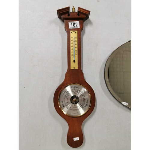 Modern barometer with a thermometer along with a bevel glass mirror ...