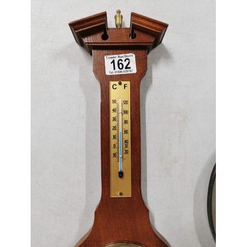 Modern barometer with a thermometer along with a bevel glass mirror ...