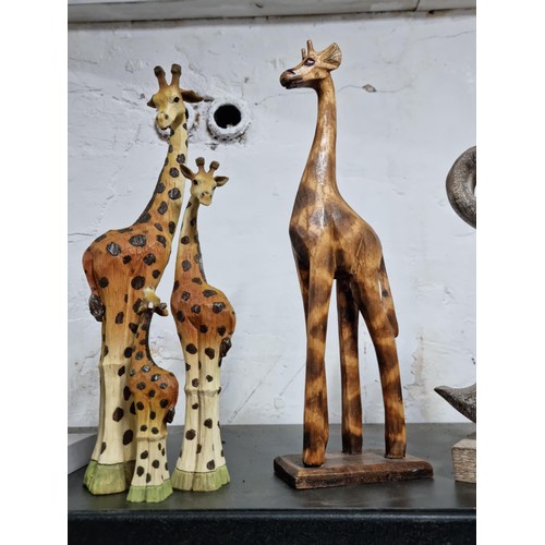 A collection of resin and wooden Giraffe figures to include a grey ...