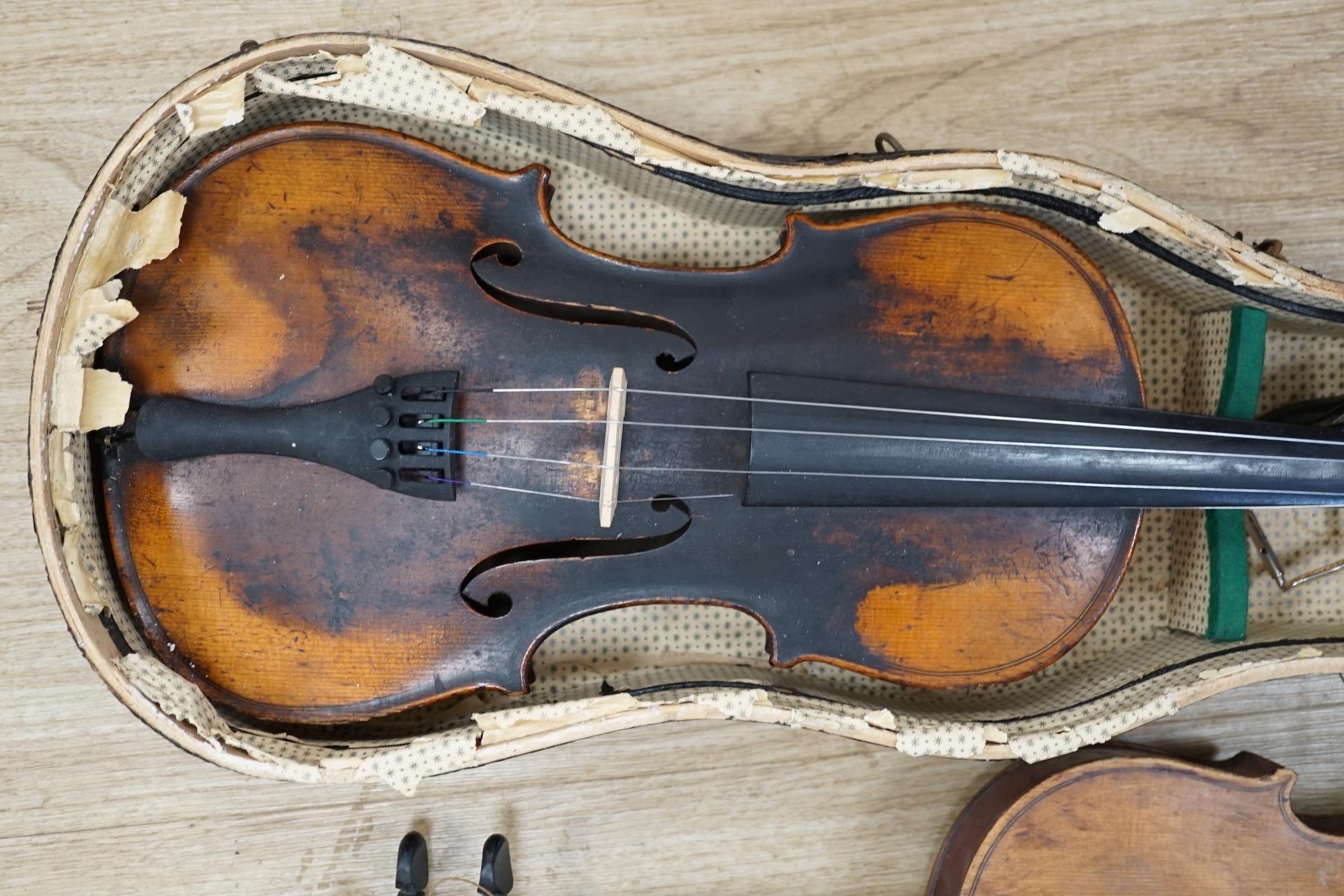 Two early 20th century violins, one in the remains of a case, both for restoration, length of bodies