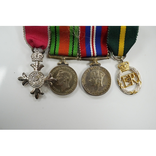 A group of 4 medals including MBE in display case