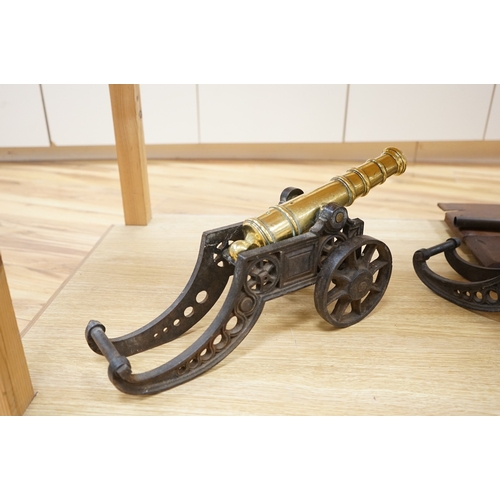 A decorative pair of brass model cannons, with turned barrels, 29cm overall, on cast iron pierced ca