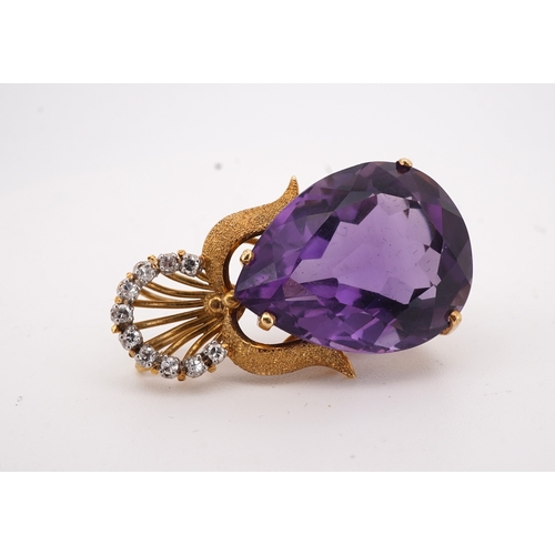 An Amethyst and diamond pendant, claw-set with a pear-shaped amethyst ...