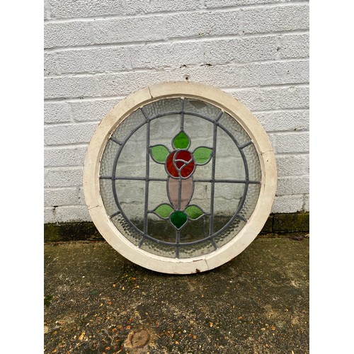 A leaded and stained glass roundel, in painted frame