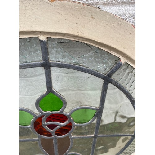 A leaded and stained glass roundel, in painted frame