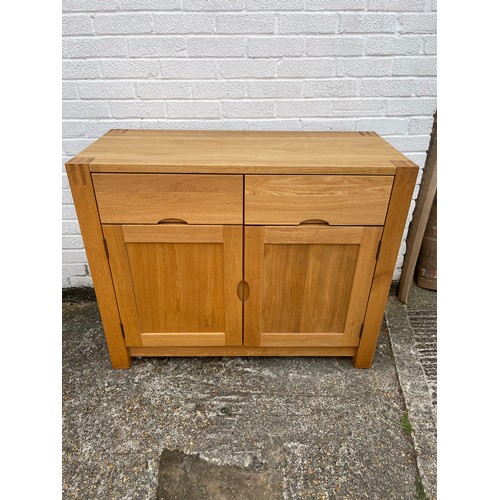 A modern oak sideboard, fitted with two drawers over cupboard doors