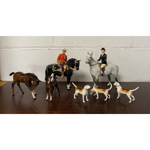 A Beswick Huntswoman, together with three hounds, a Mountie on ...