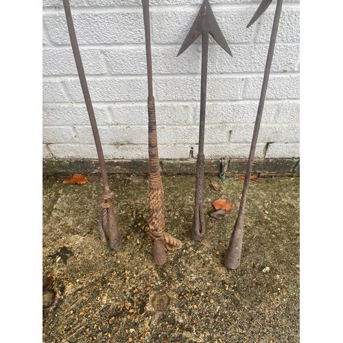 A group of antique whale harpoons, and a union flag on pole