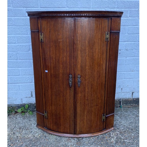 A 19th Century oak bow fronted corner cupboard