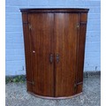 A 19th Century oak bow fronted corner cupboard